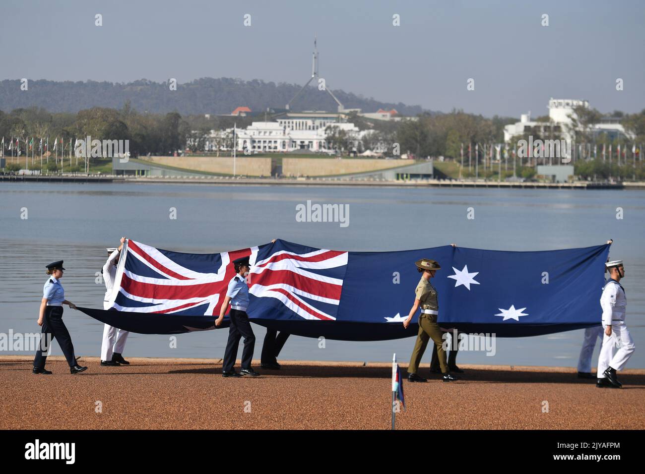 Defence personnel march past with the Australian flag during an ...