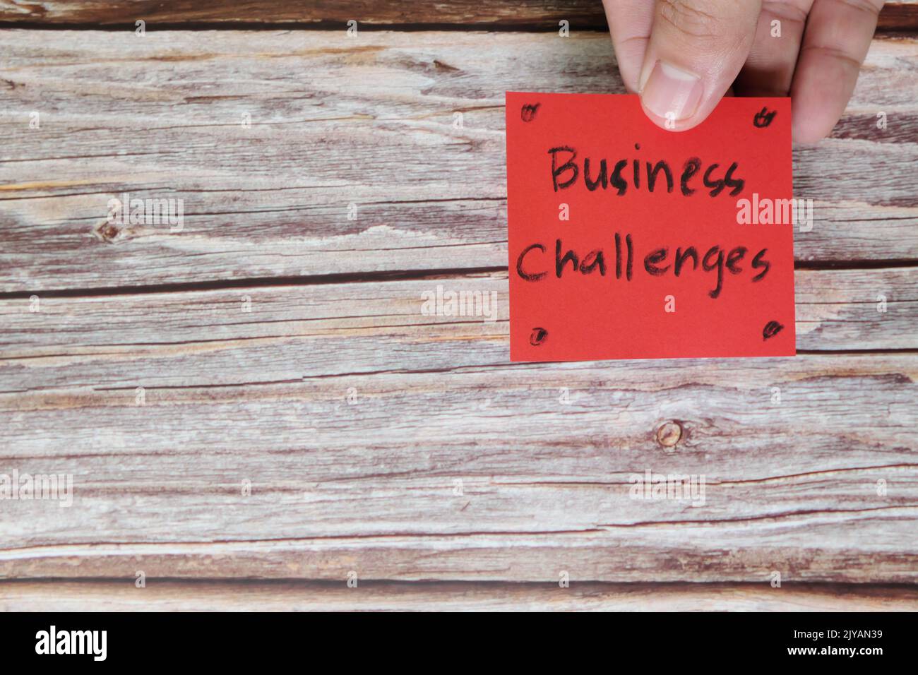 Handling business challenges concept. Hand holding red note with ...