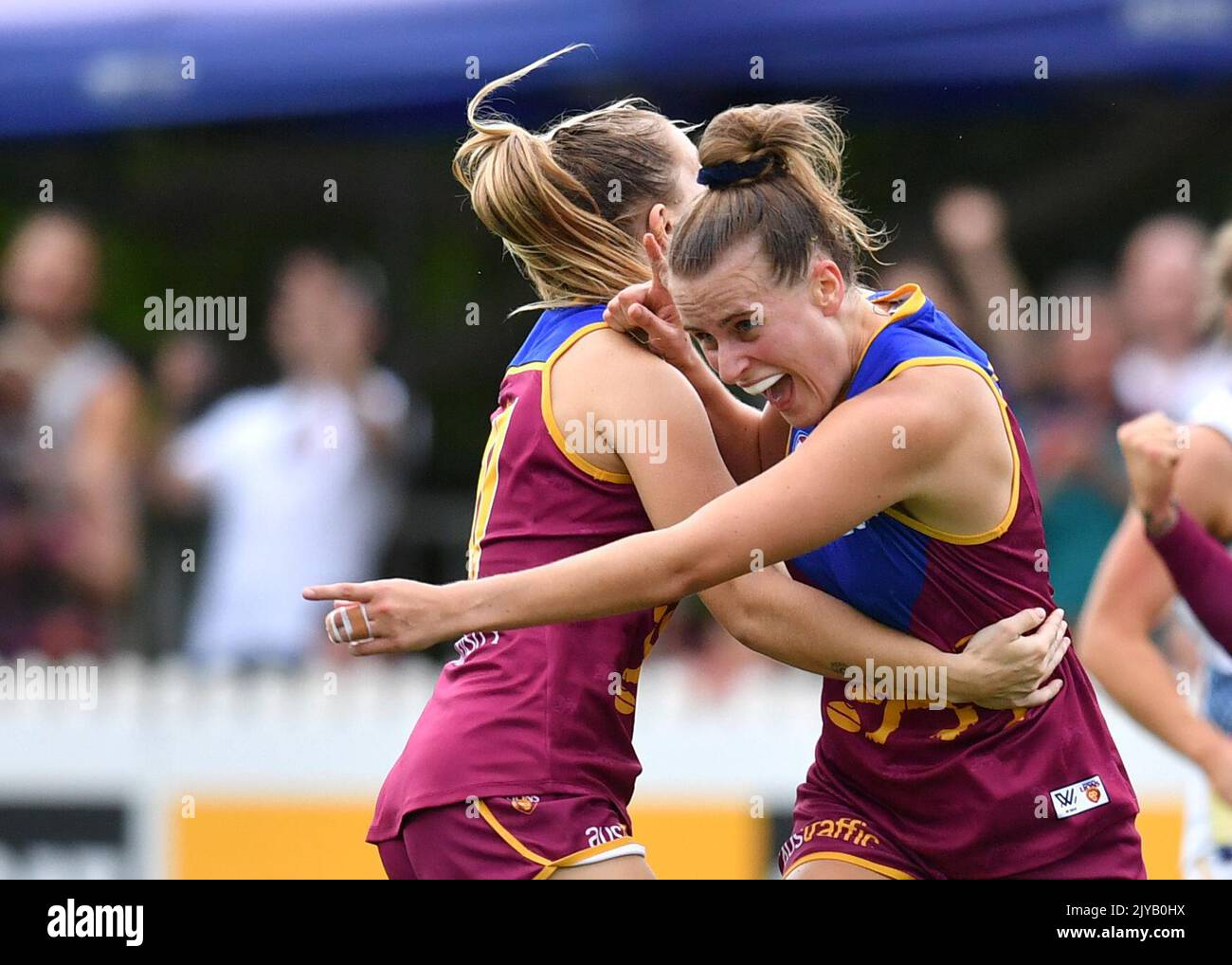 Greta Bodey (right) of the Lions celebrates kicking a goal with team ...