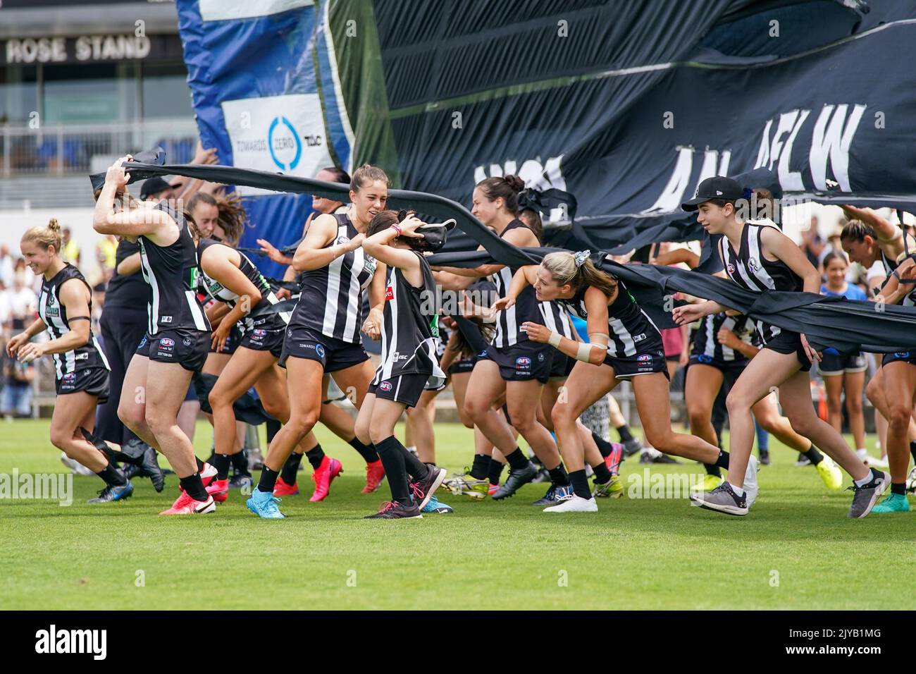 The Magpies run through banner during the Round 1 AFLW match between ...