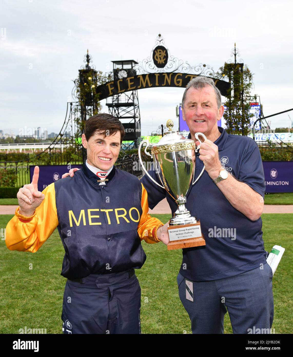Jockey Craig Williams lifts the trophy with Metro coach Denis Pagan ...