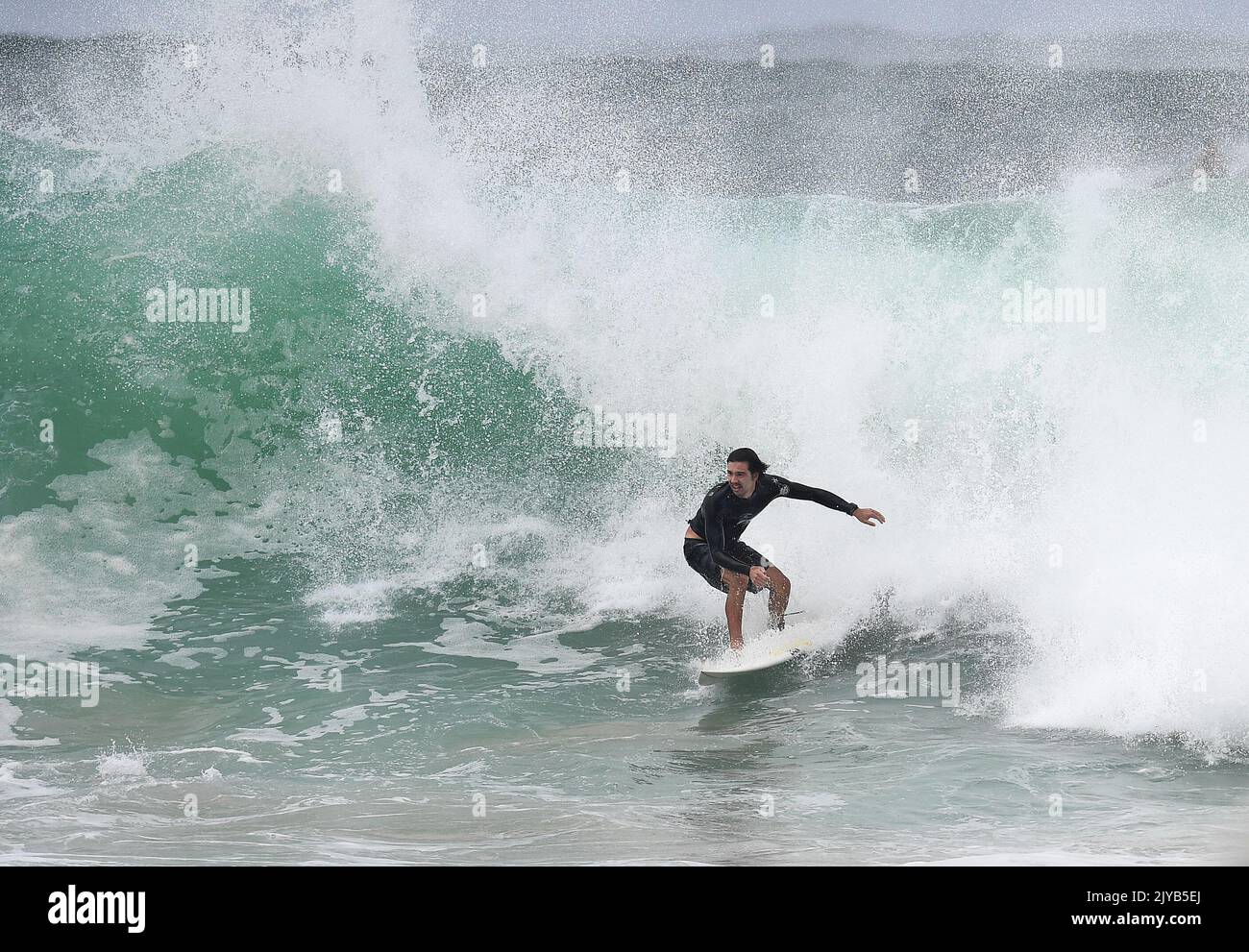 A surfer takes advantage of big waves generated by Ex-tropical cyclone ...