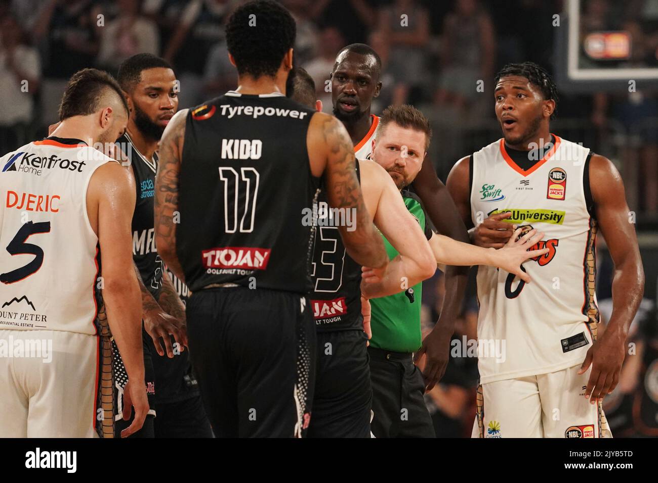 The referee holds back Cameron Oliver of the Taipans during a scuffle ...