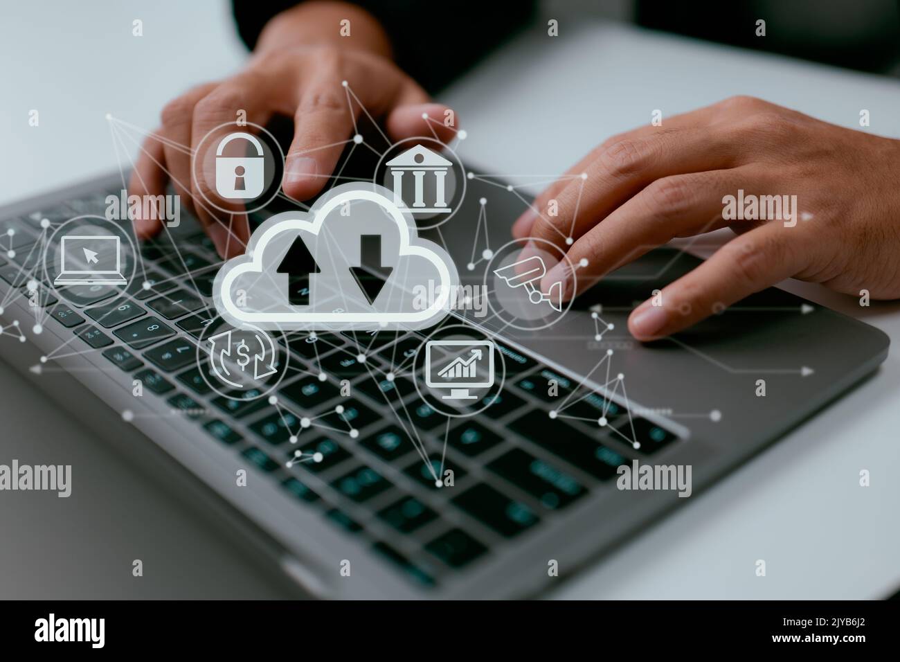 A man works on a laptop that has a diagram of cloud computing on it ...