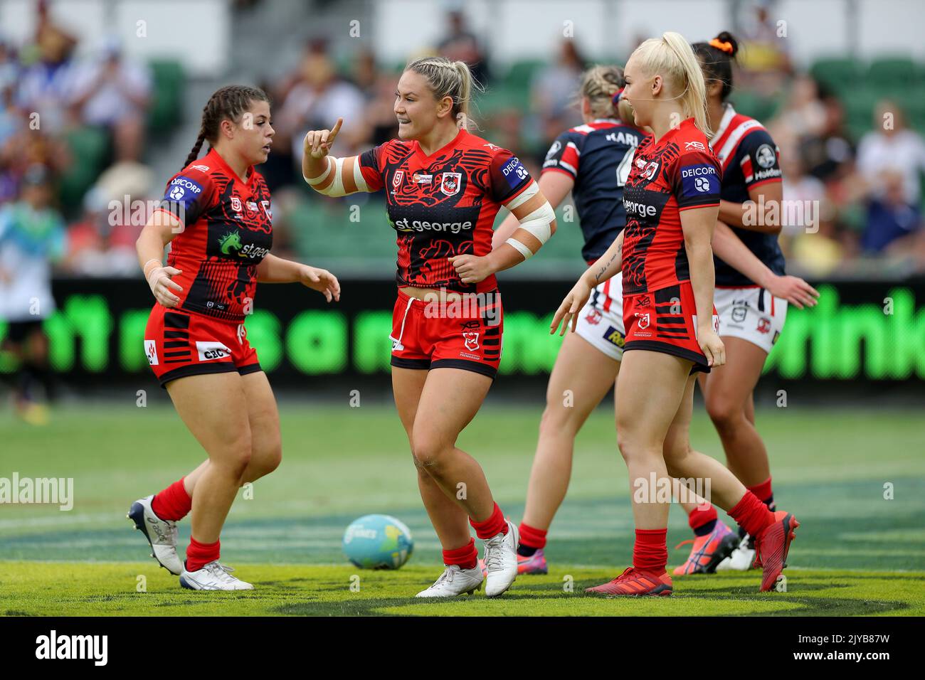 Keeley Davis (centre) of the Dragons celebrates after scoring a try ...