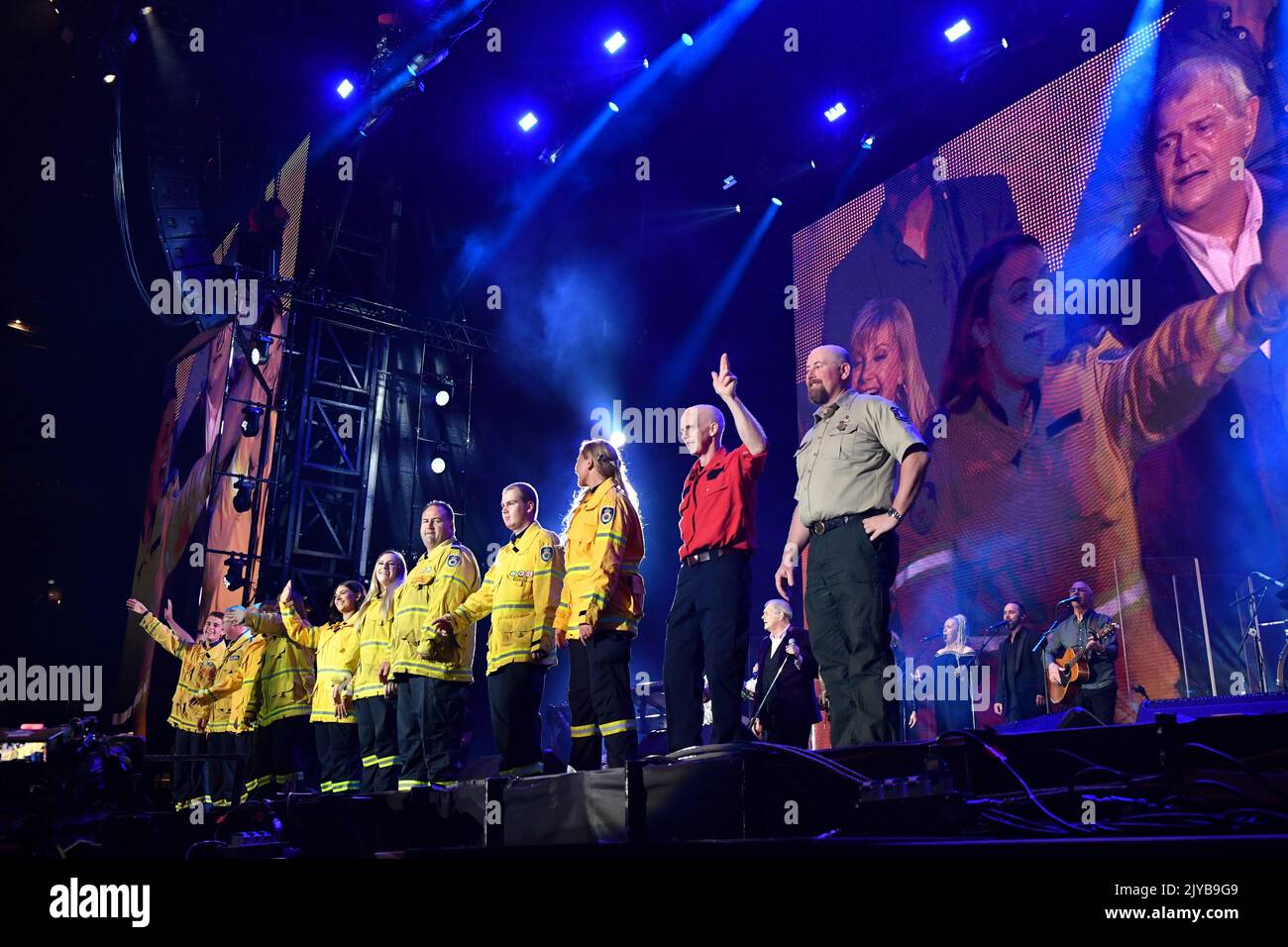 Firefighters join John Farnham (left) and Olivia Newton-John on stage ...