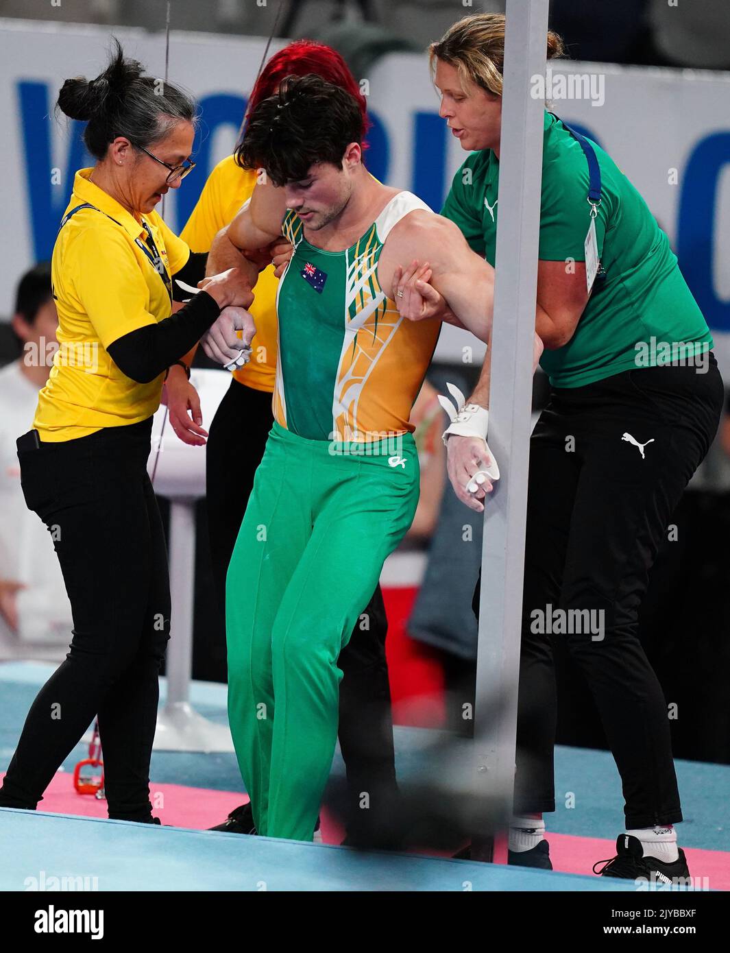 Clay Mason Stephens of Australia is helped by officials after injuring ...