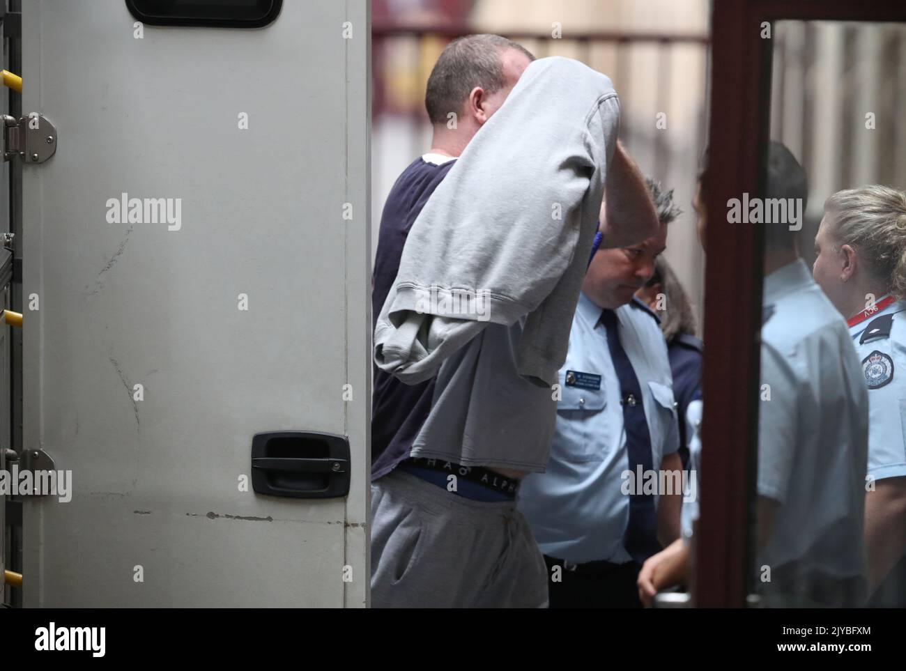 Scott Murdoch covers his face as he is taken into the Victorian Supreme ...
