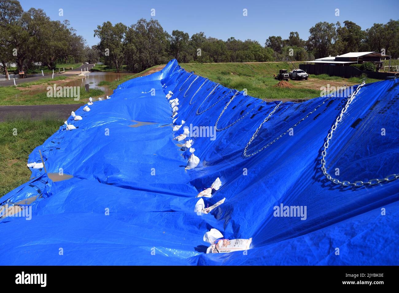 A levee protects homes from the swollen Balonne river in St George ...