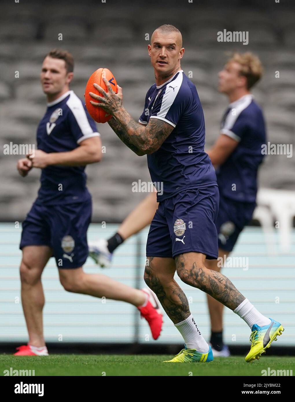 Dustin Martin of Victoria runs with the ball as Patrick Dangerfield ...