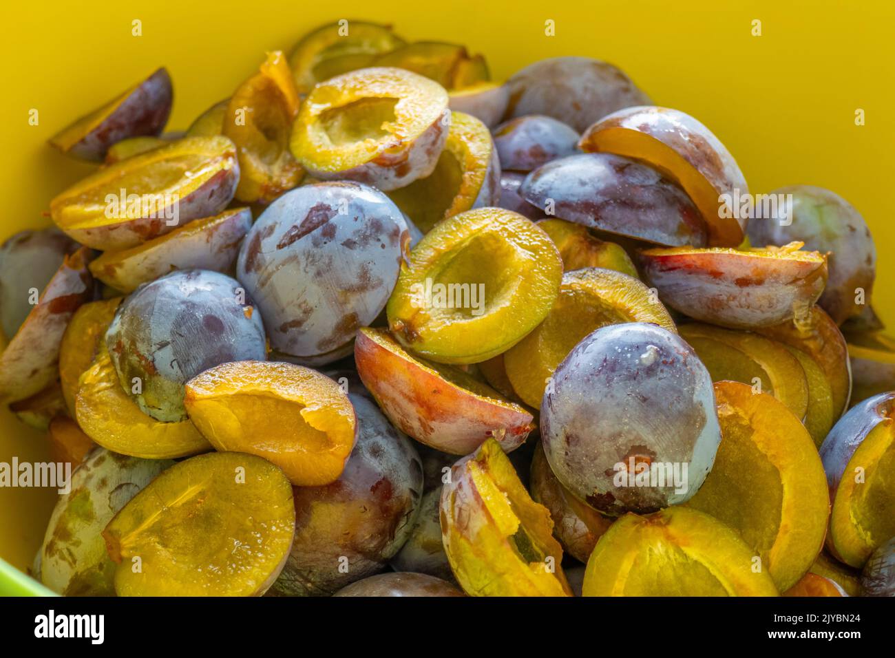 Plum halves .Yellow pulp of fruits in a yellow cup. Juicy pulp texture ...