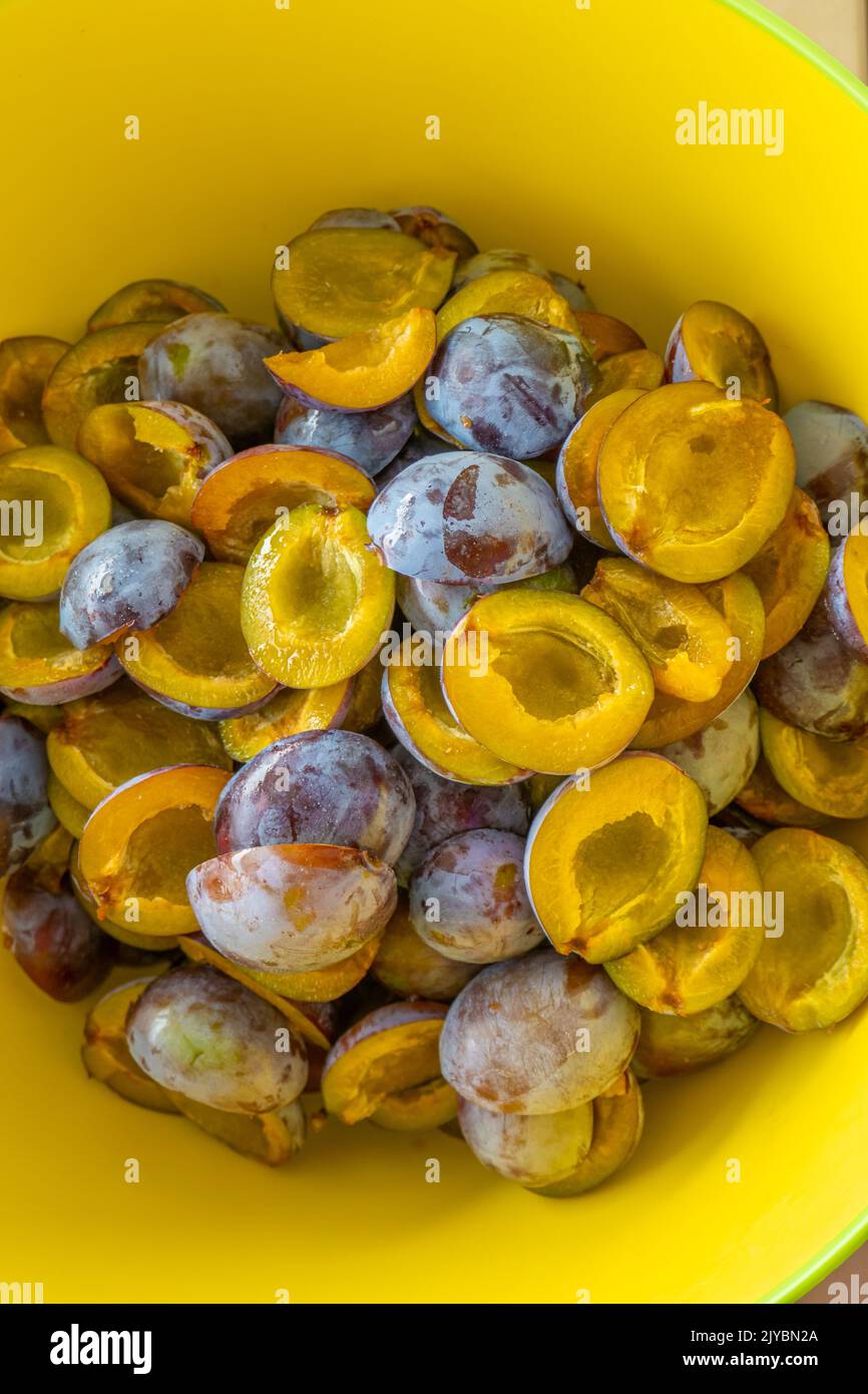Plum halves.Yellow pulp of fruits in a yellow cup. Juicy pulp texture ...