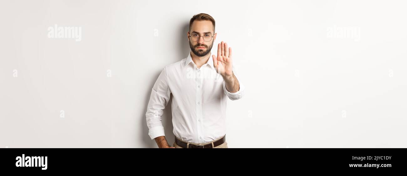 Serious boss in glasses showing stop sign, telling no, forbidding ...