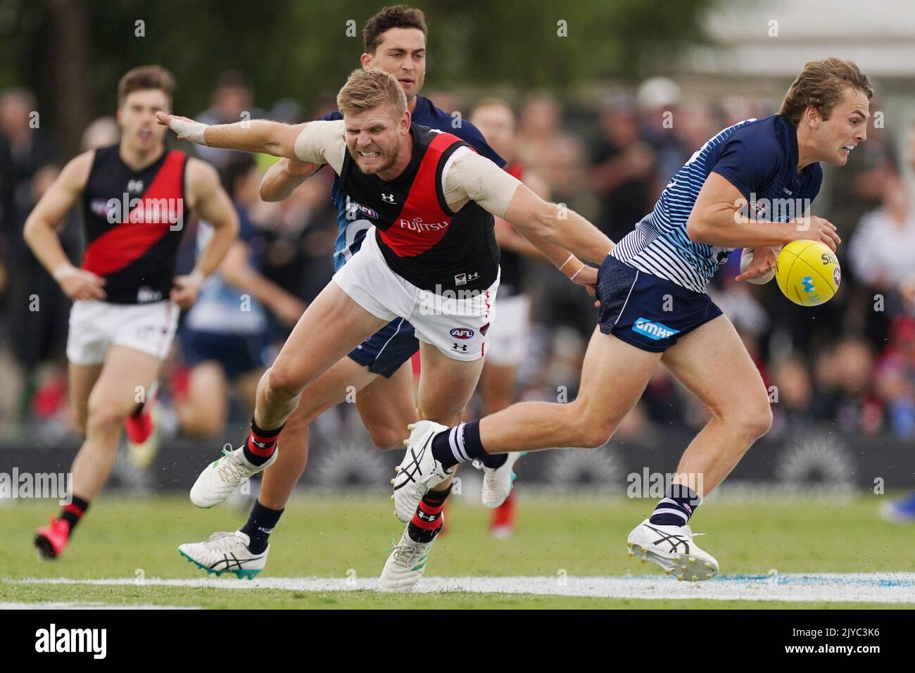 Tom Atkins of the Cats runs with the ball from Michael Hurley of the ...