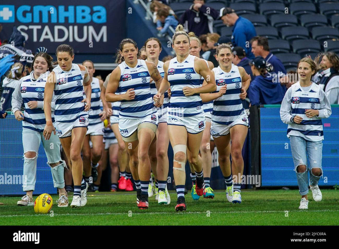 Cats players are seen running onto the ground during the Round 6 AFLW ...