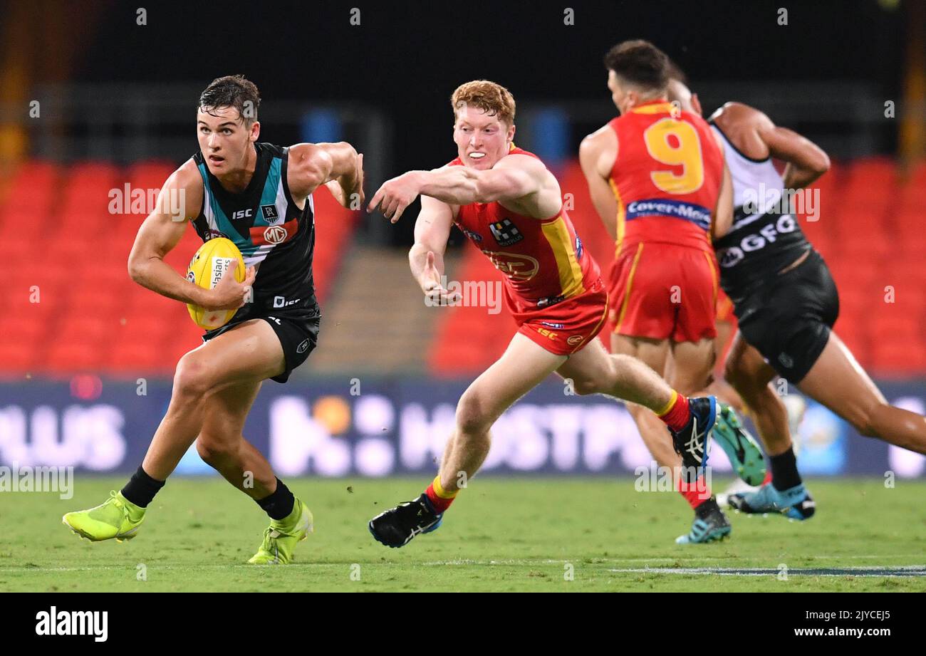Connor Rozee (left) of the Power gets past Matthew Rowell (centre) of ...