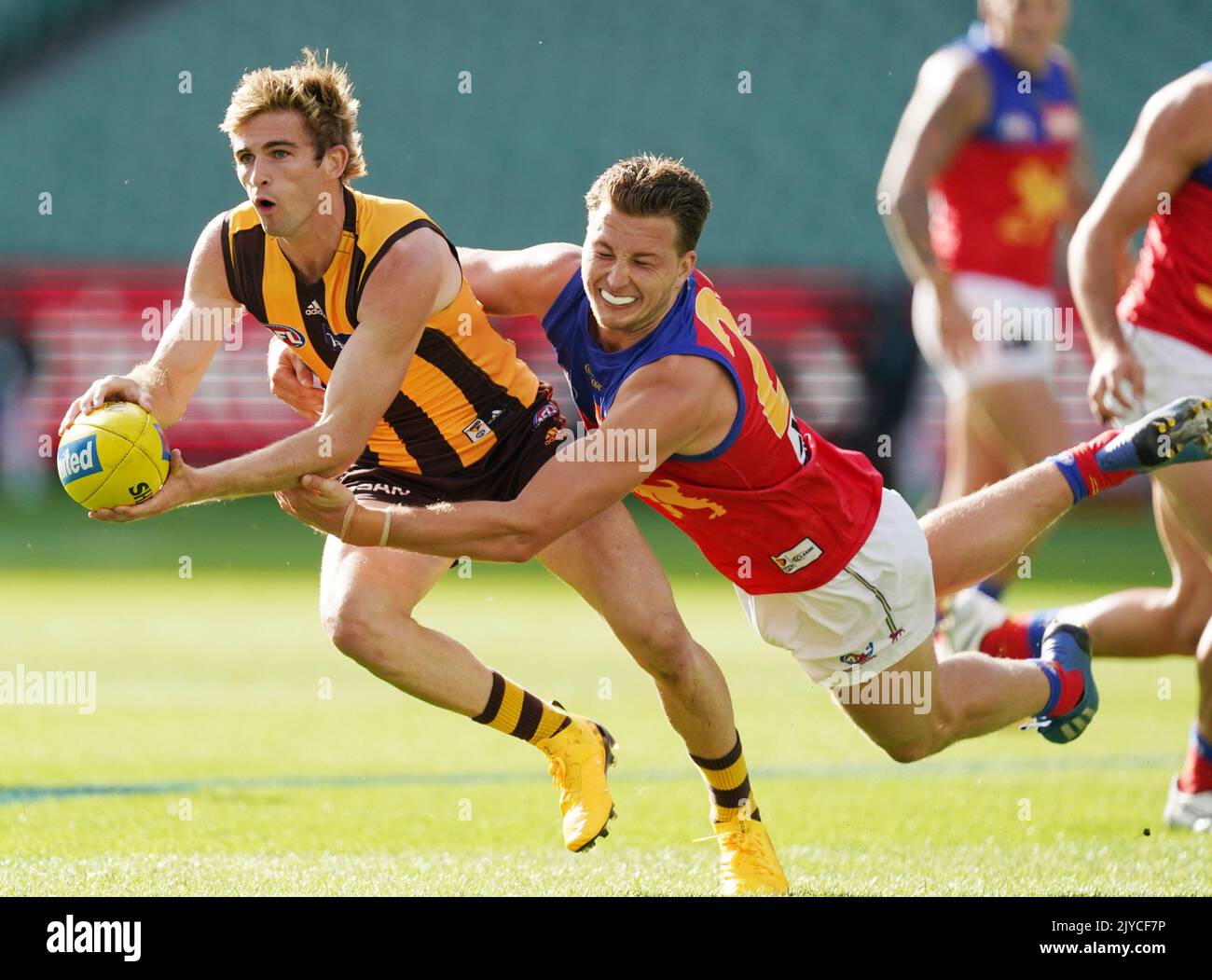 Oliver Hanrahan of the Hawks handballs from Alex Witherden of the Lions ...