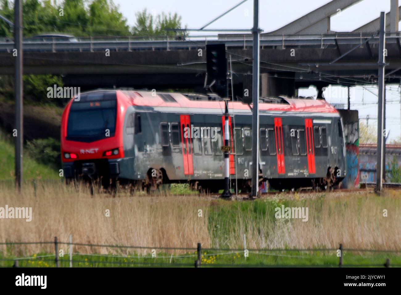 Red and black train vehicle of R-Net heading to Gouda from Alphen in ...