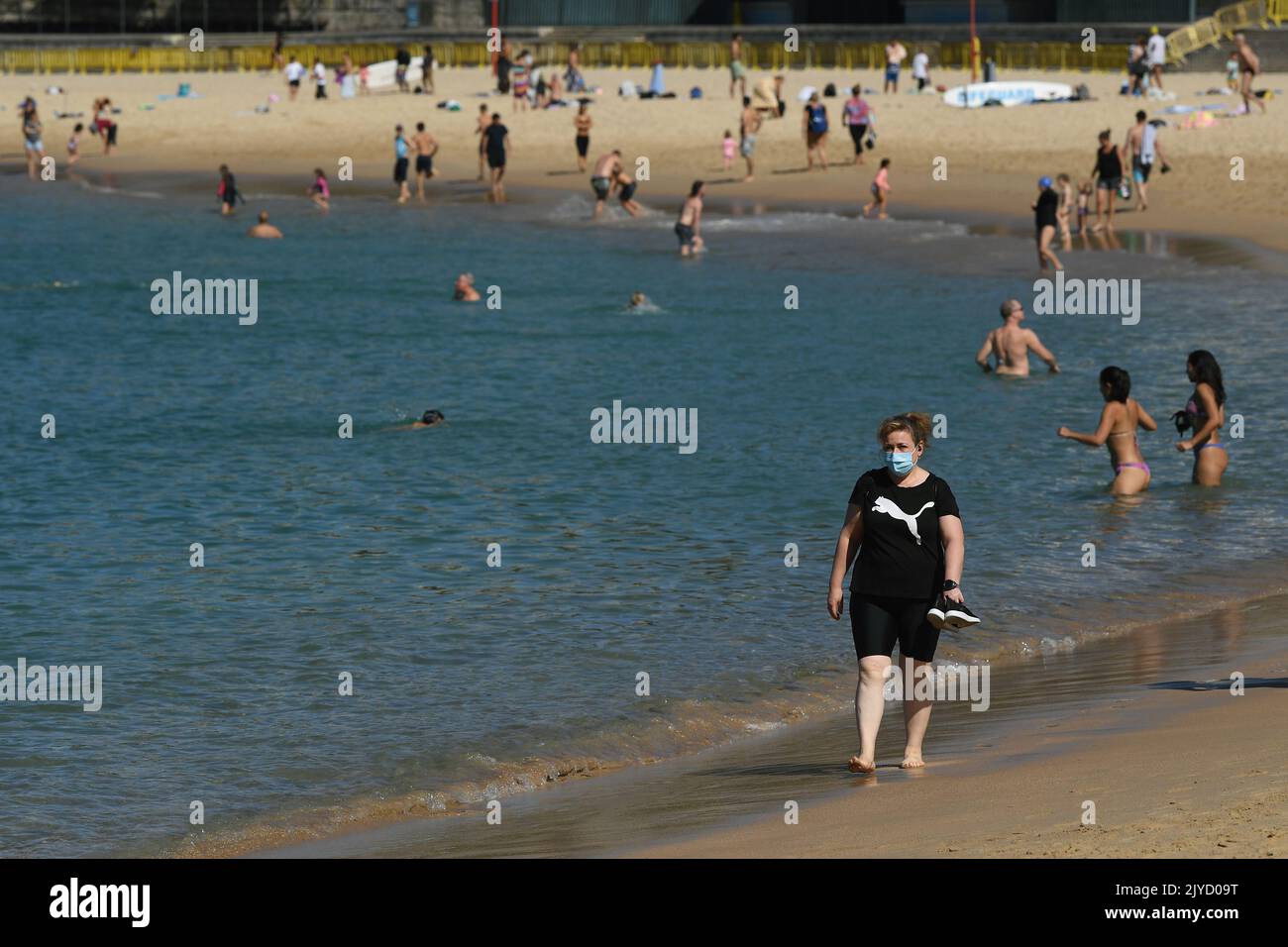 Beachgoers swimming and exercising on the sand at Coogee Beach in ...