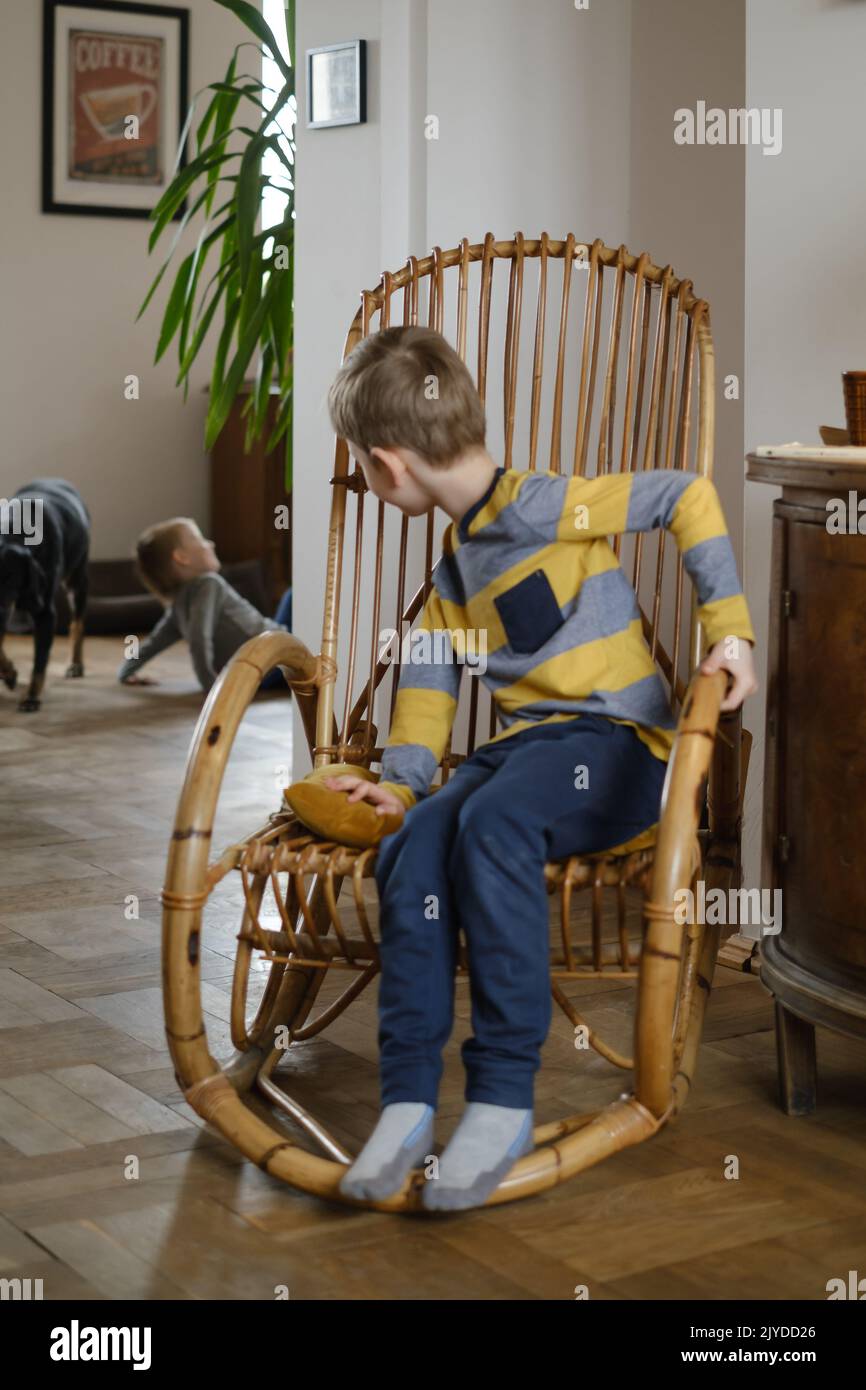 Child in rocking chair in vintage house. Retro home for family. Boy kid ...