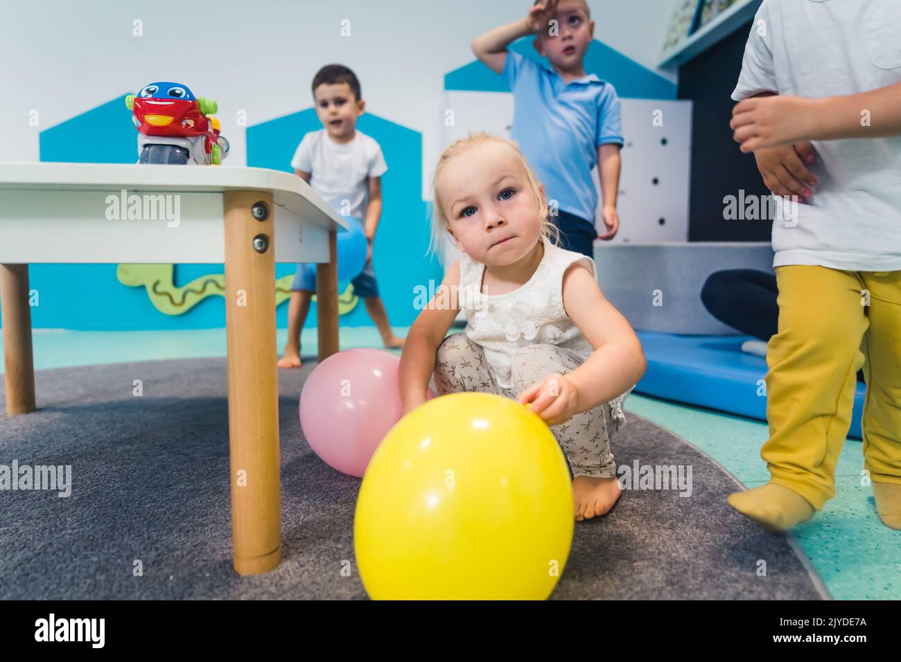 Toddler caucasian girl playing colorful balloons. Sensory play at the ...