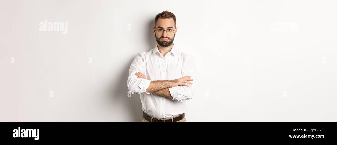 Disappointed businessman pouting, standing displeased against white ...