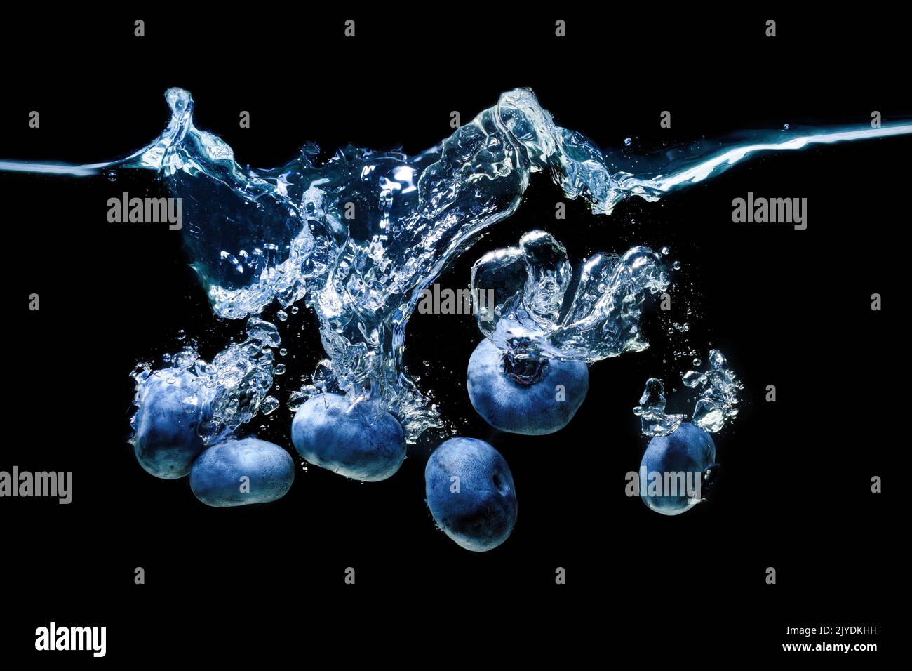Bunch of fresh blueberries dropped in water with air bubbles and ...