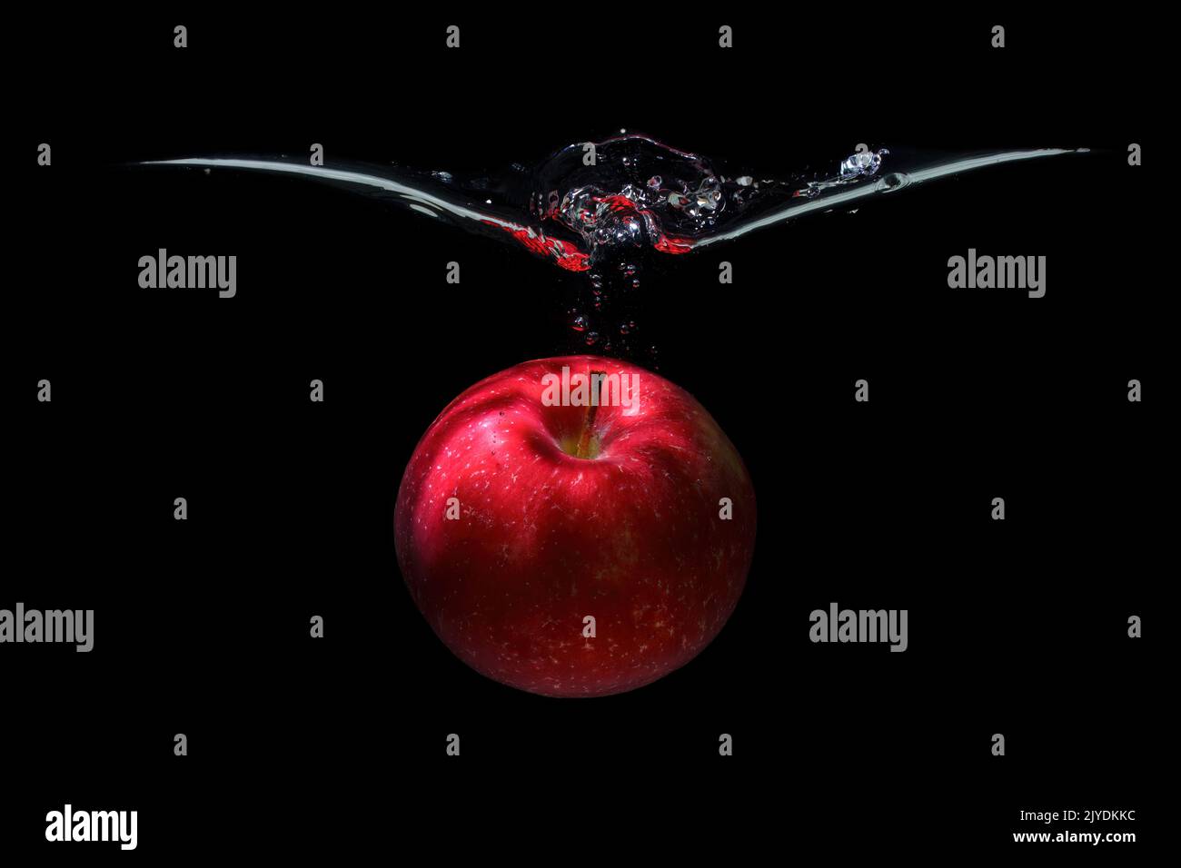 Red apple dropped in water with splashes isolated on black background ...