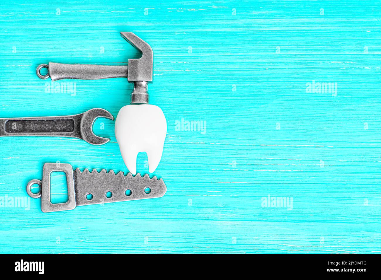 Human tooth model and steel copies of hand tools isolated on a blue ...