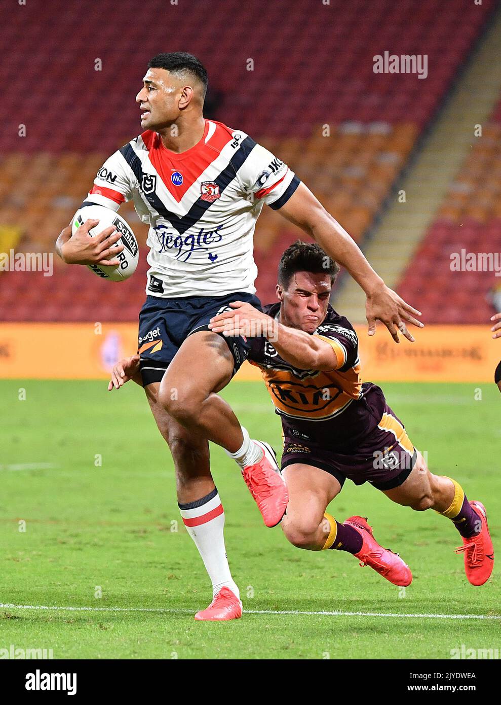 Daniel Tupou of the Roosters gets through a tackle by Brodie Croft of ...