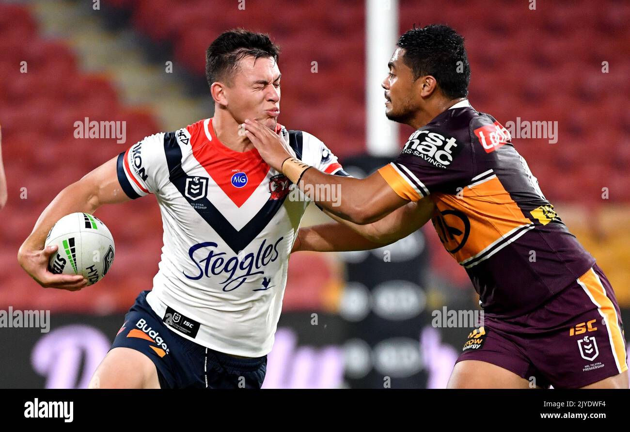 Joseph Manu (left) of the Roosters is tackled by Anthony Milford (right ...