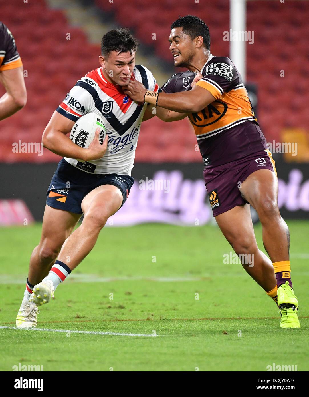 Joseph Manu (left) of the Roosters is tackled by Anthony Milford (right ...