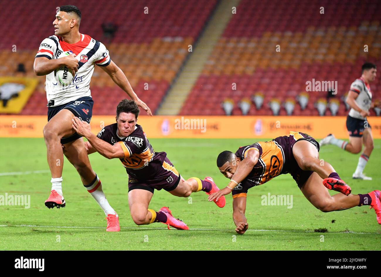 Daniel Tupou of the Roosters gets through tackles by Brodie Croft and ...