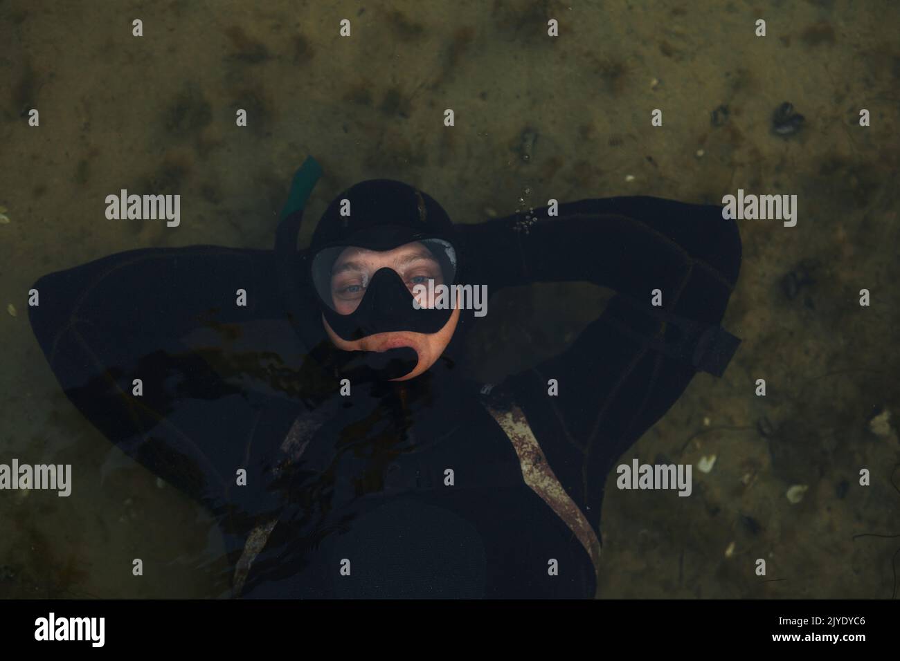High angle view of an adventurous young man relaxing in sea water with ...