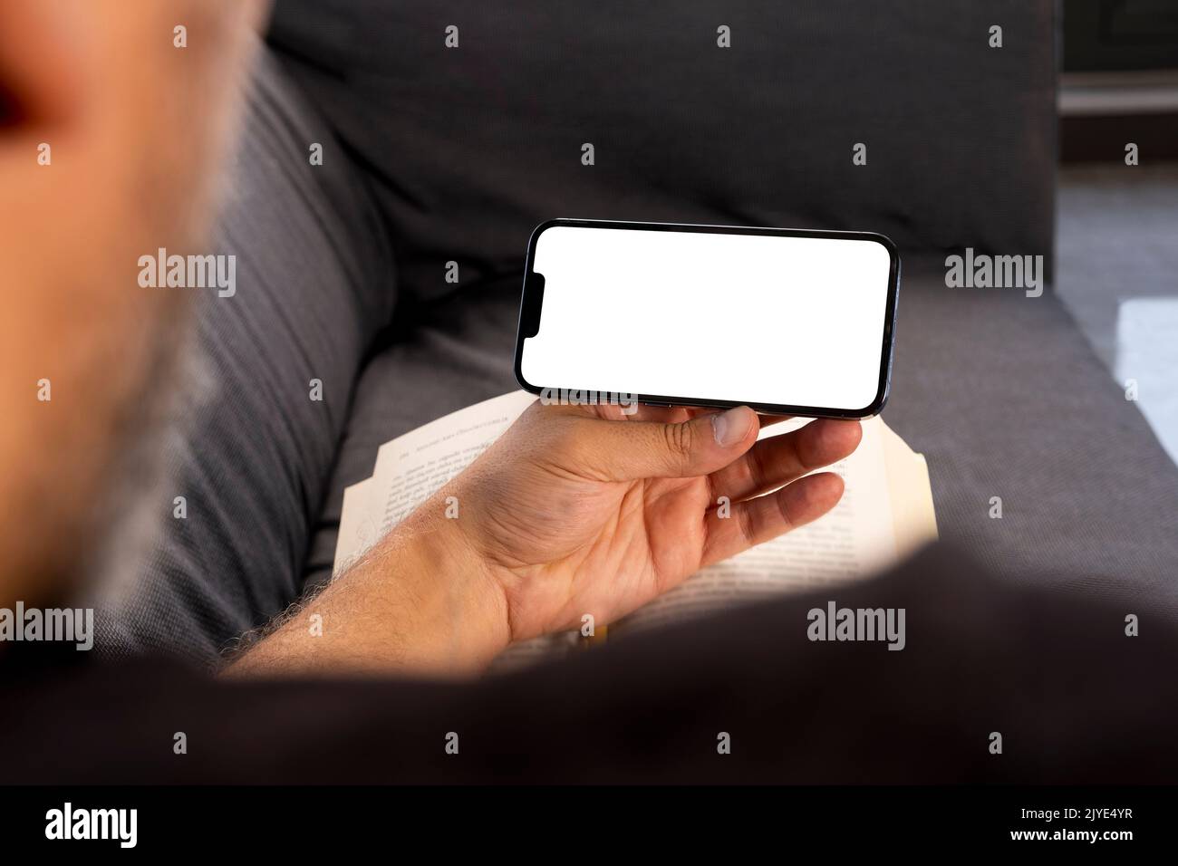 Holding horizontal smartphone, over shoulder view of holding horizontal ...