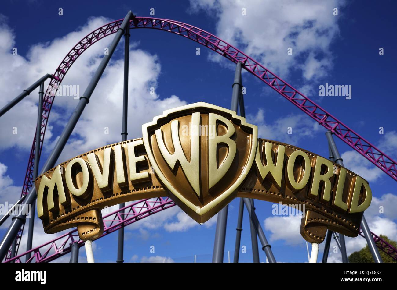A Warner Brothers Movie World sign is seen in front of a roller-coaster ...