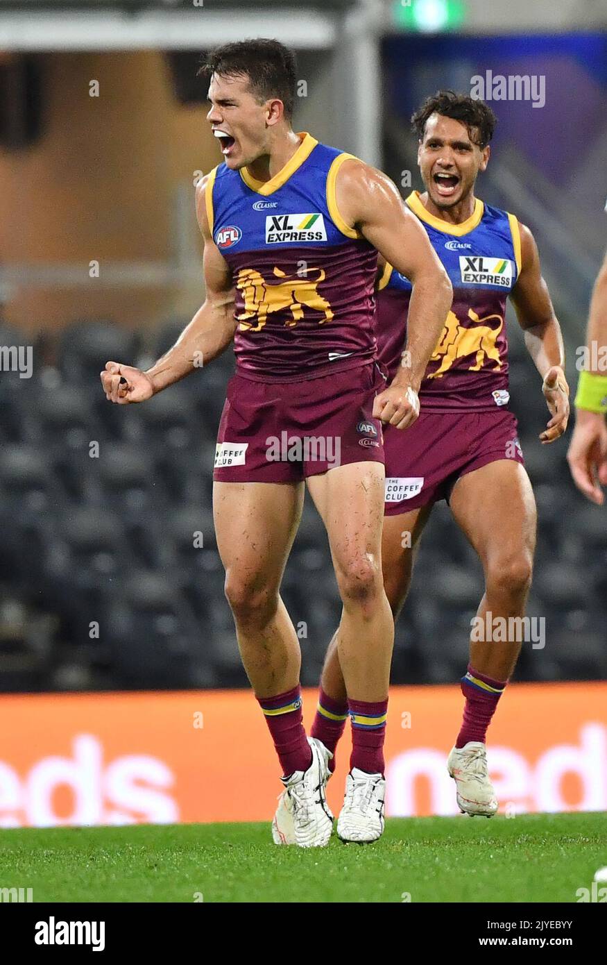 Brandon Starcevich (left) of the Lions celebrates kicking a goal during ...