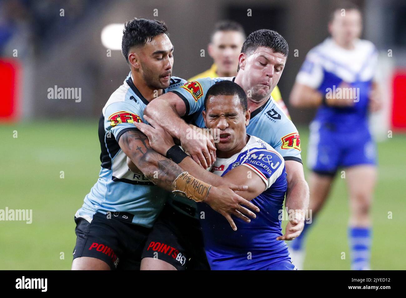 Briton Nikora and Chad Townsend of the Sharks tackle Will Hopoate of ...