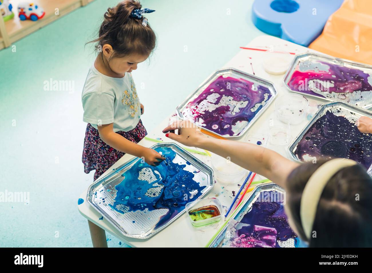 Sensory play for brain development at nursery school. Toddlers playing ...