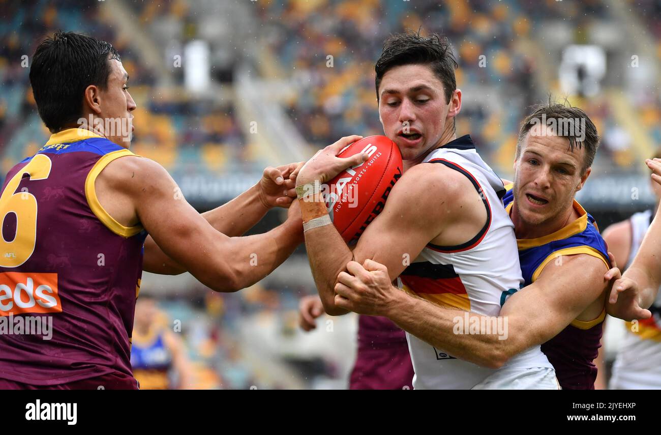 Chayce Jones (centre) of the Crows is tackled by Lincoln McCarthy ...
