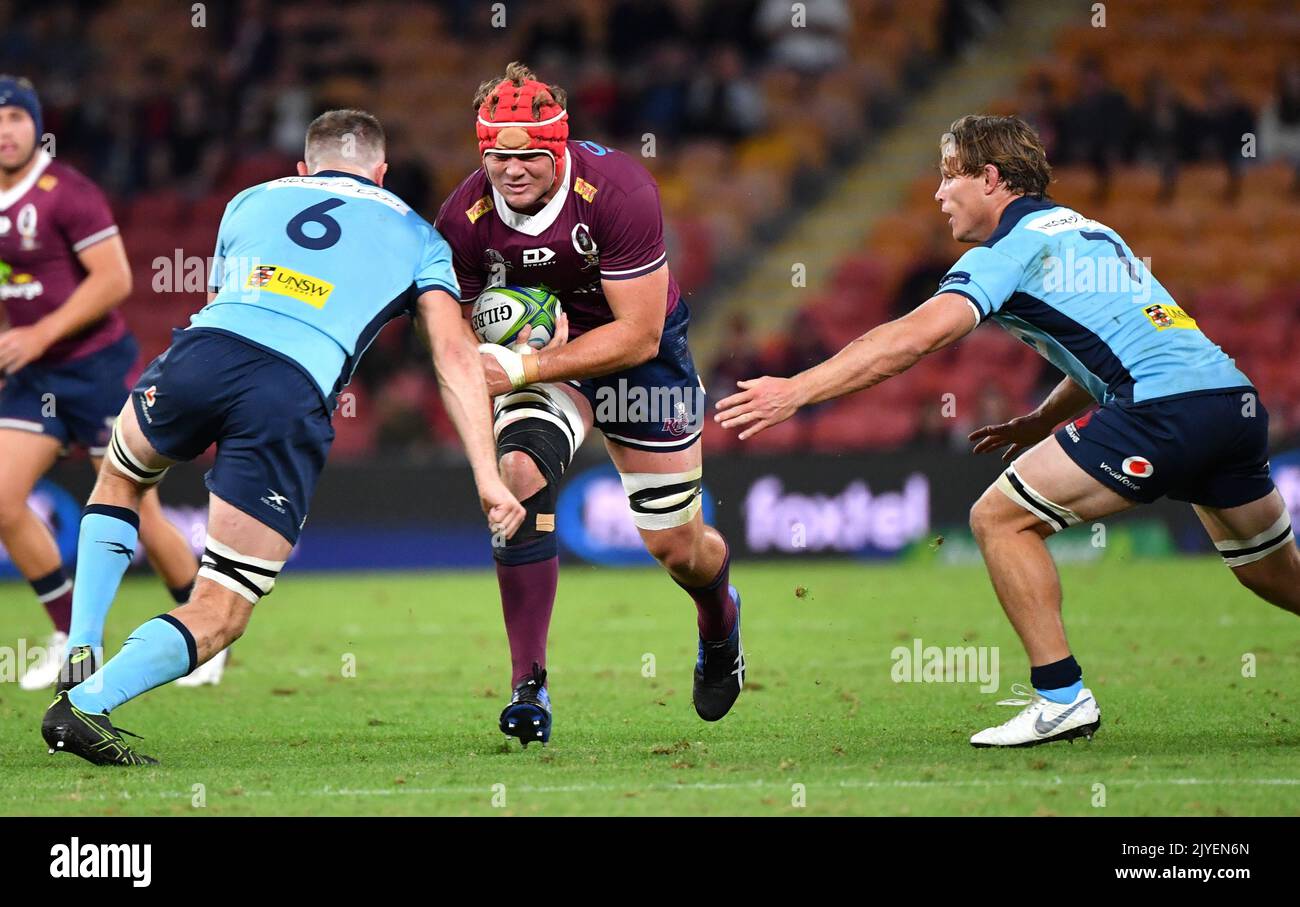 Harry Wilson (centre) of the Reds is tackled by Lachlan Swinton (left ...