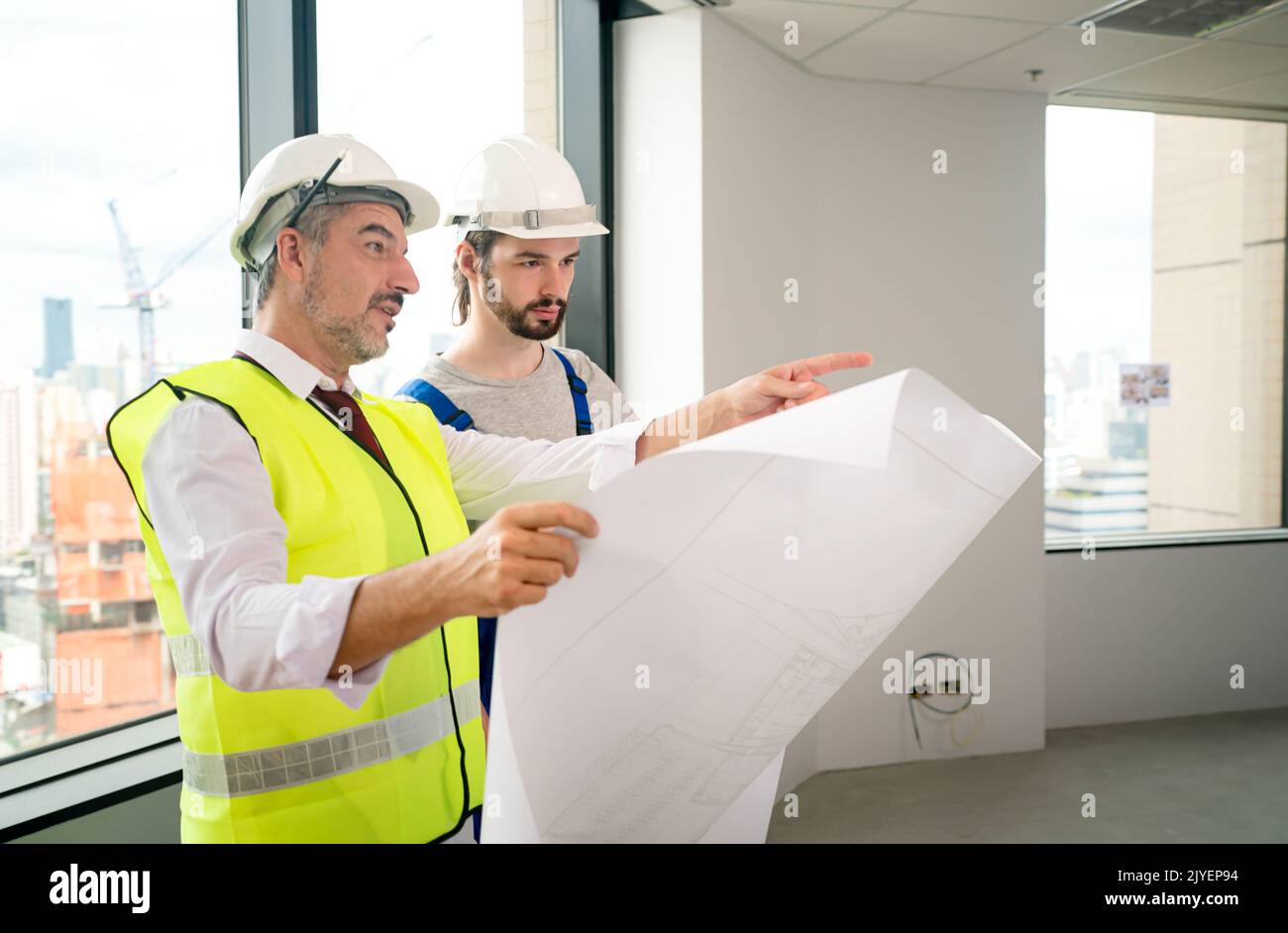 Construction engineer with foreman worker checking construction site ...