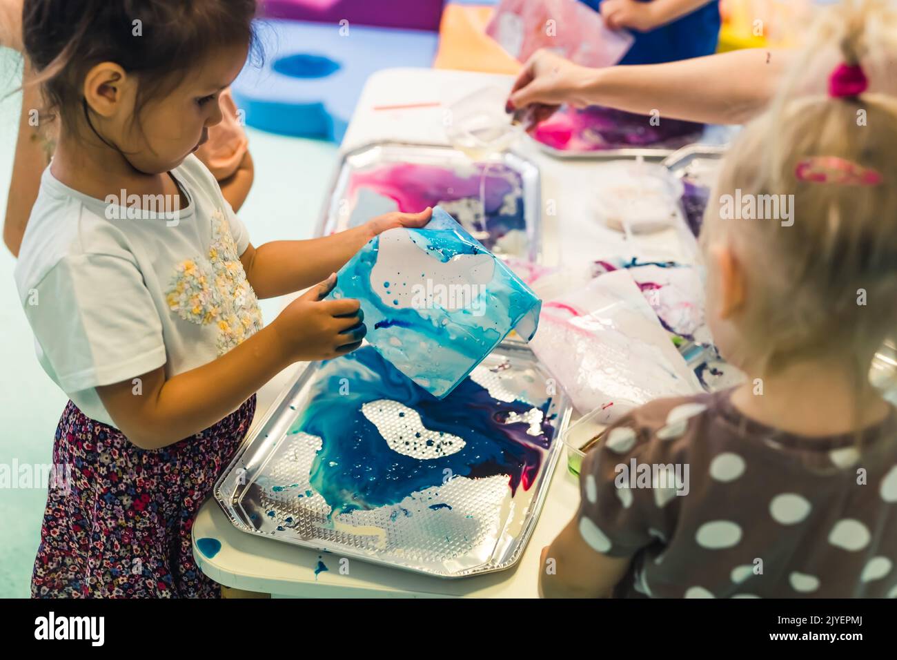 Sensory play at multi-cultural nursery school. Toddlers with their ...