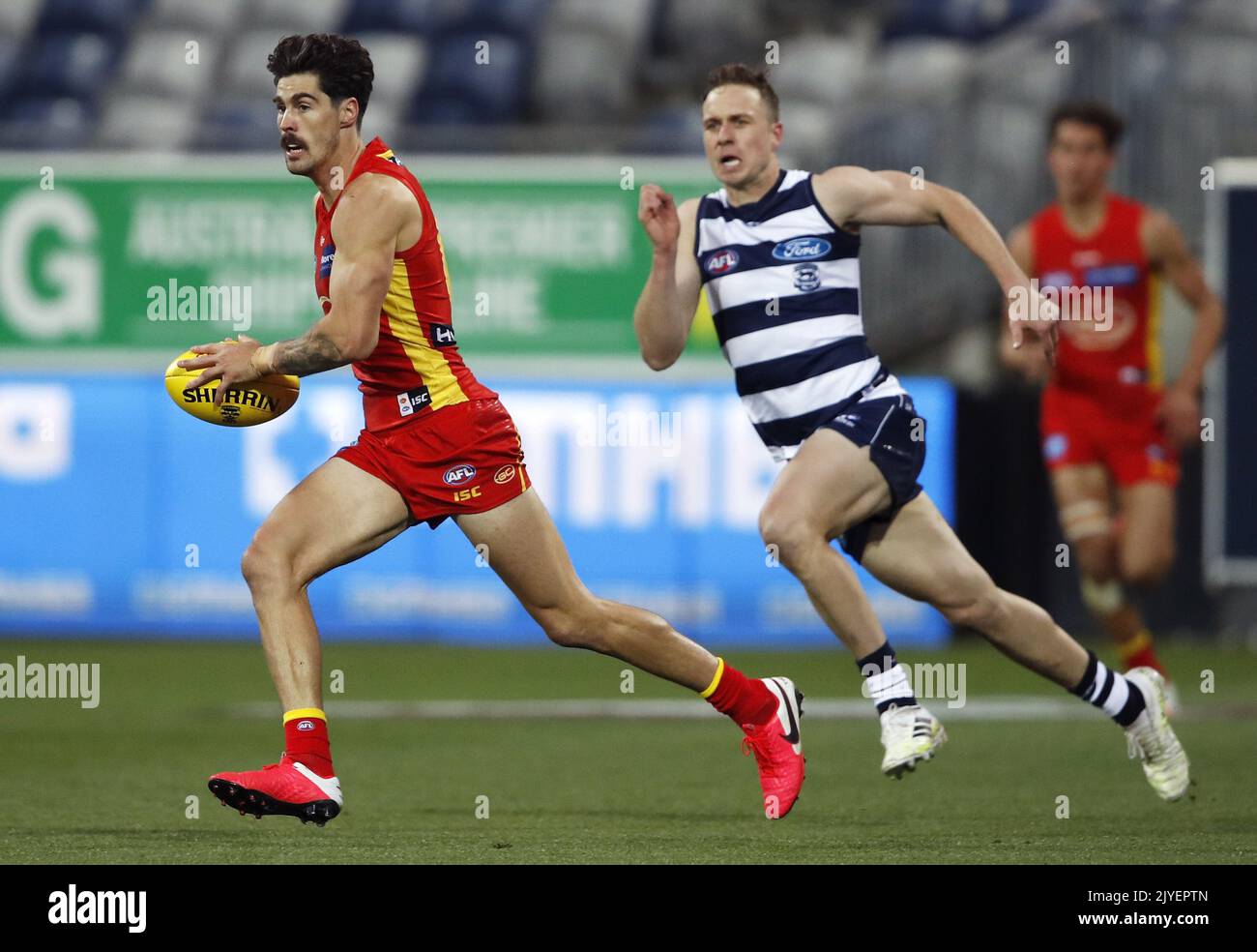 Alex Sexton of the Suns in action ahead of Mitch Duncan of the Cats ...