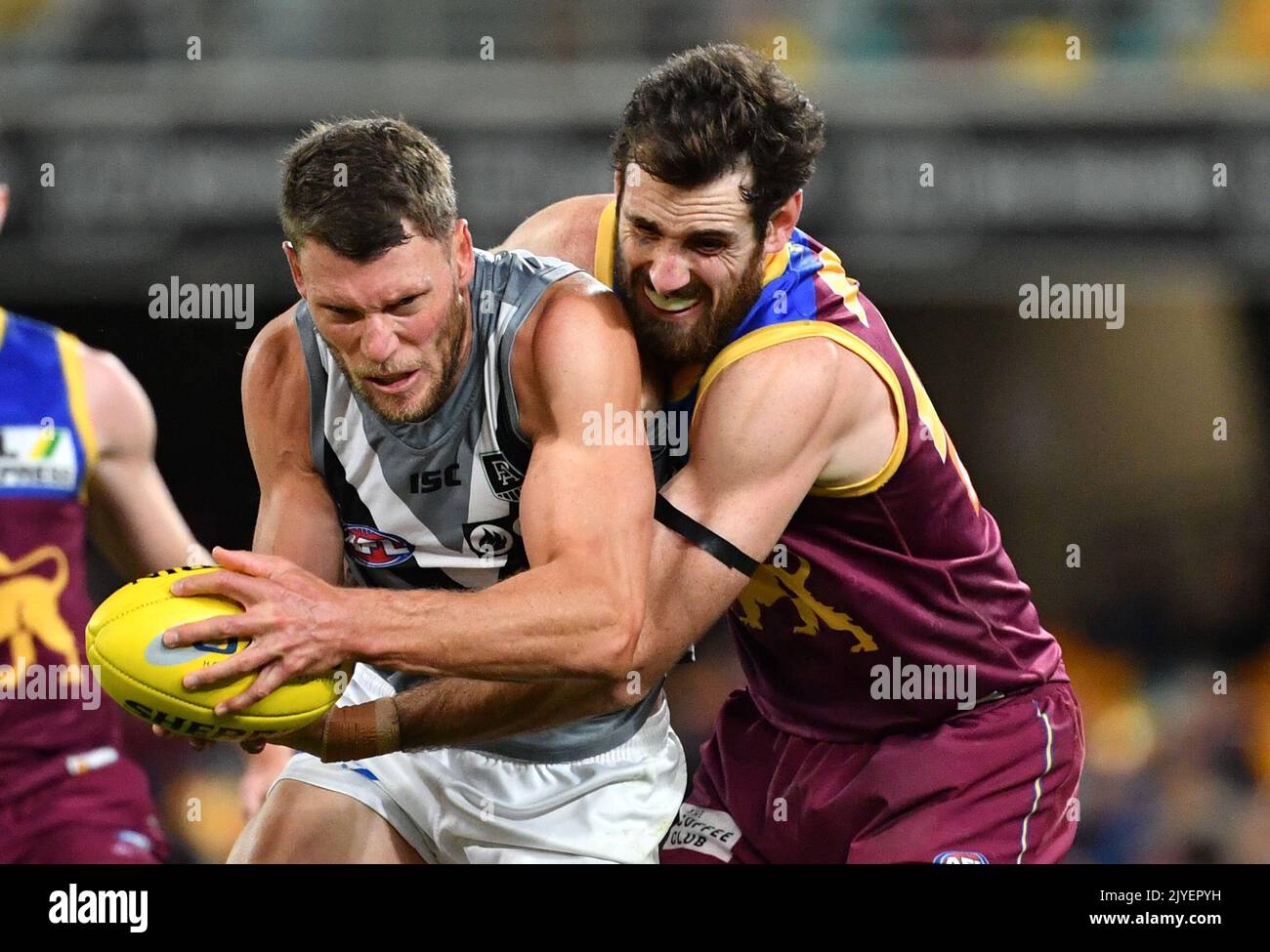 Brad Ebert (left) of the Power is tackled by Darcy Gardiner (right) of ...