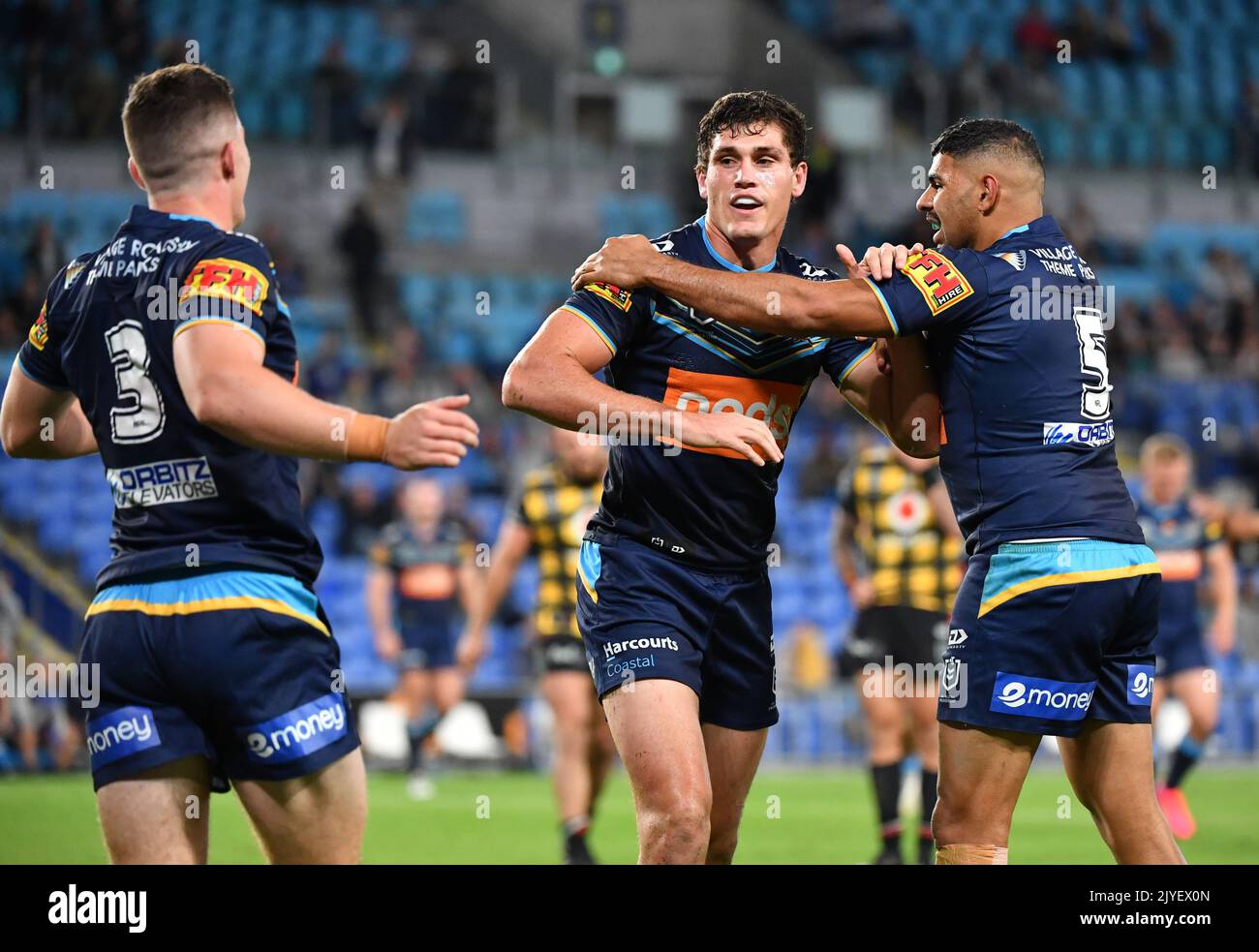 Sam Stone (centre) of the Titans celebrates scoring a try with team ...
