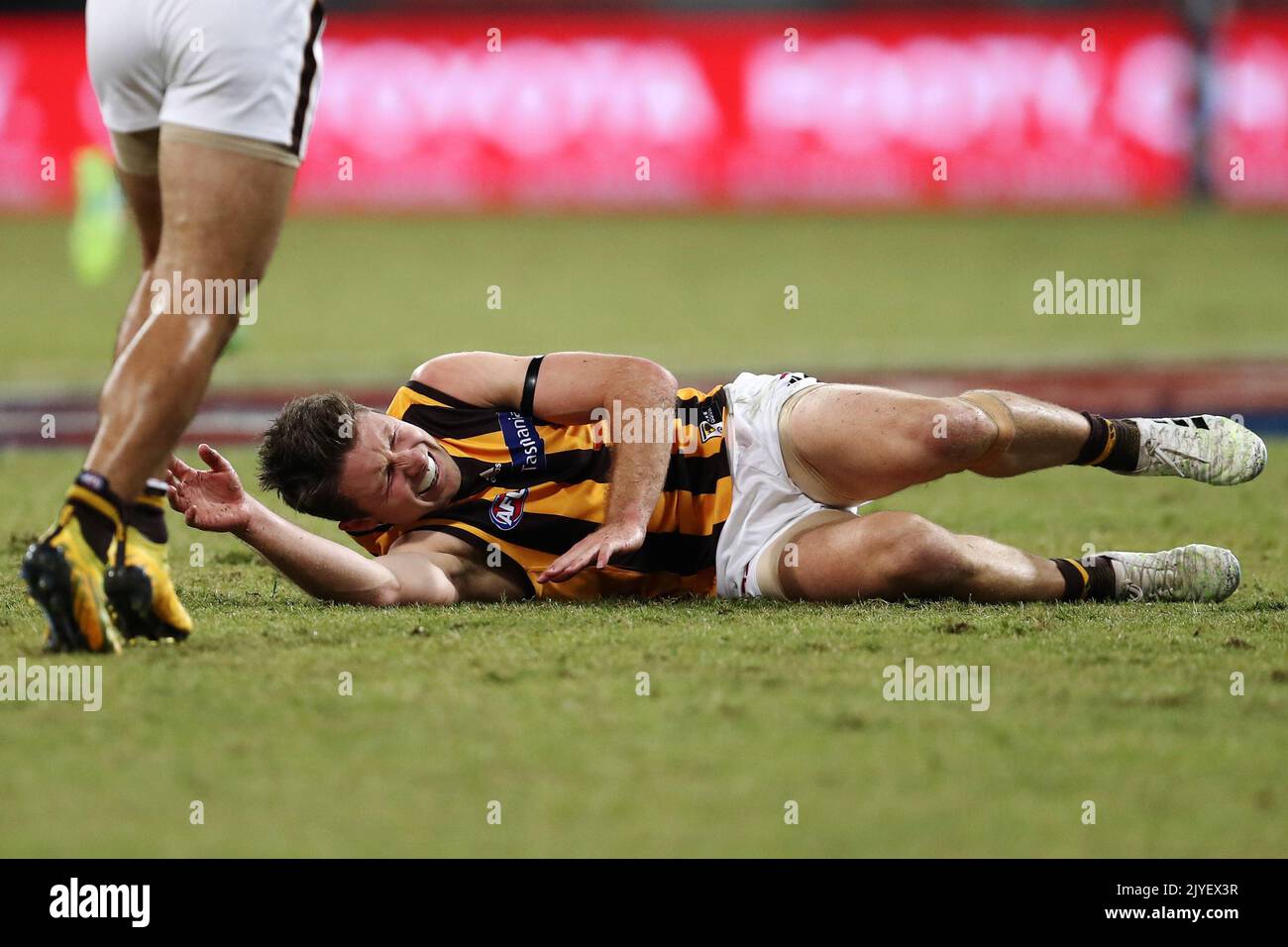 Liam Shiels of the Hawks lays on the ground after a hit from Travis ...