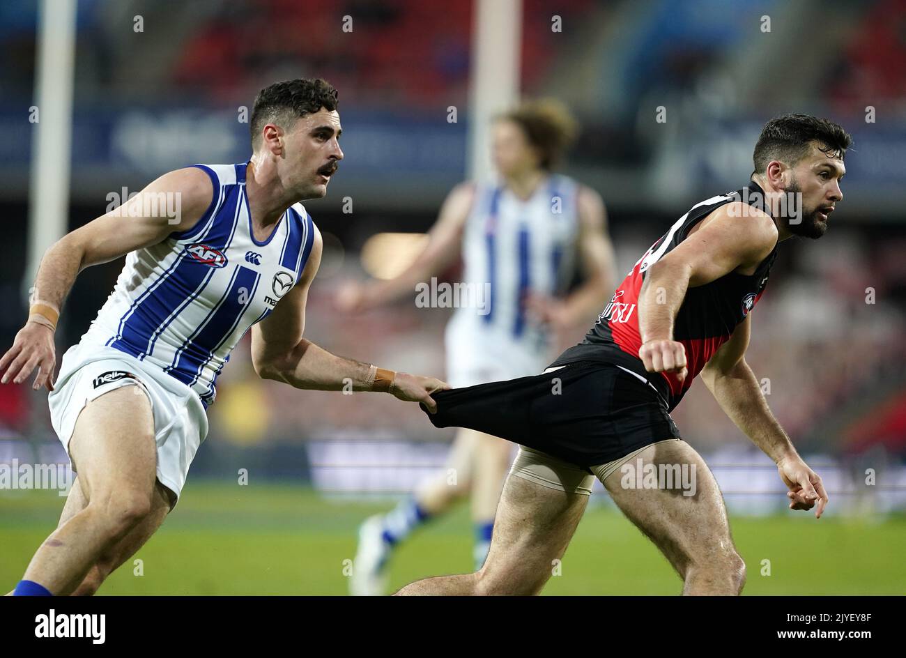 Paul Ahern of the Kangaroos pulls at the shorts of Conor McKenna of the ...