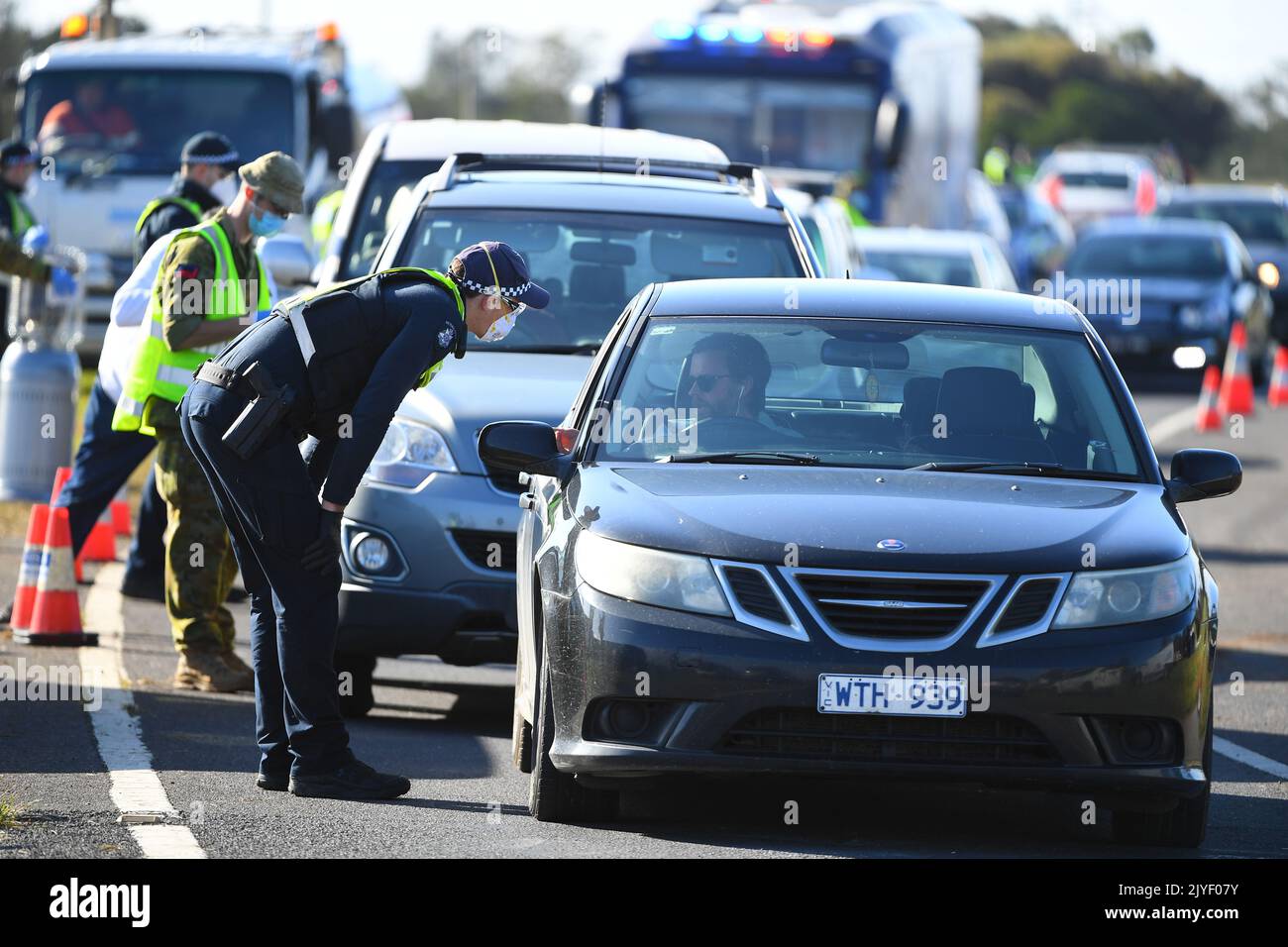 Victoria Police and ADF personnel work at a vehicle checkpoint along ...