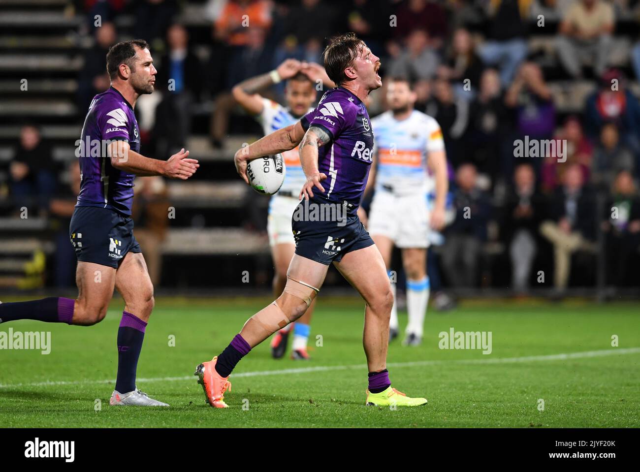 Cameron Munster of the Storm (right) celebrates scoring a try during ...